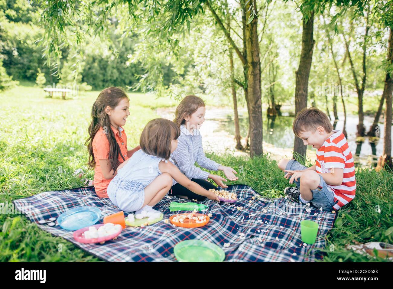 Little children eating lunch outdoors. Kids with picnic basket in ...