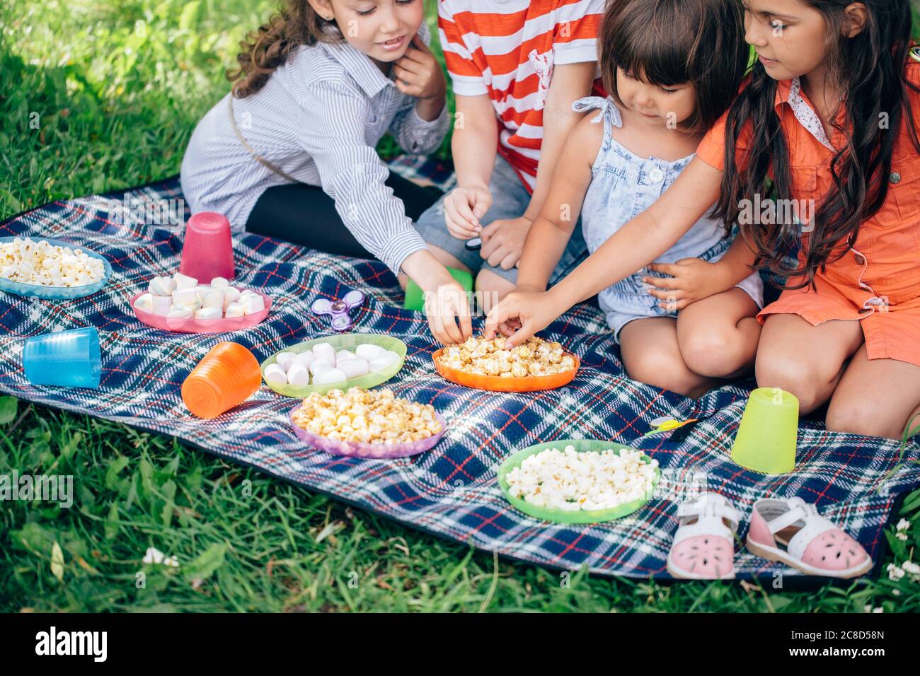 Little children eating lunch outdoors. Kids with picnic basket in ...