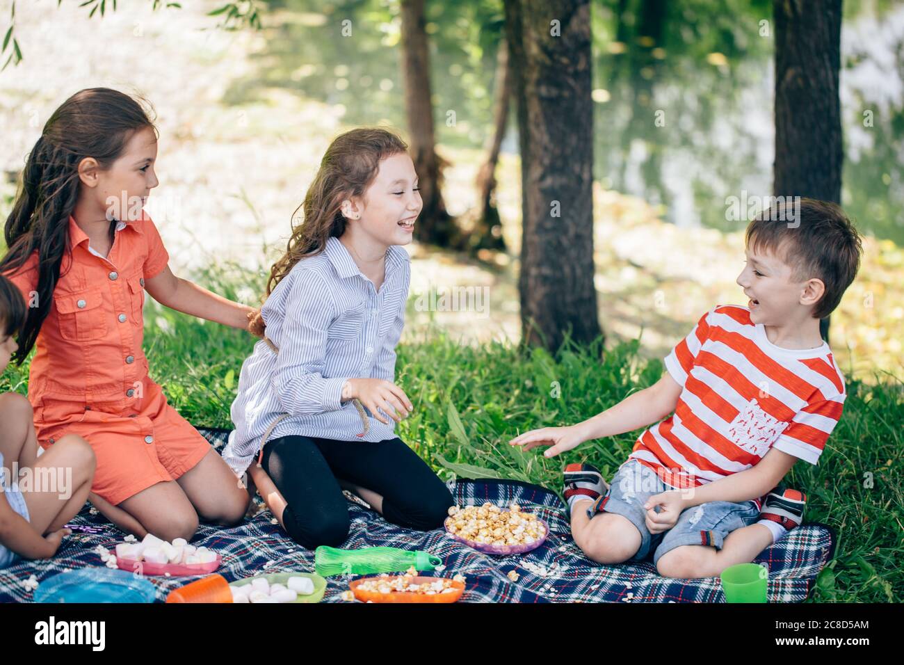 Portrait of three Children having fun in the garden in summer. They are ...