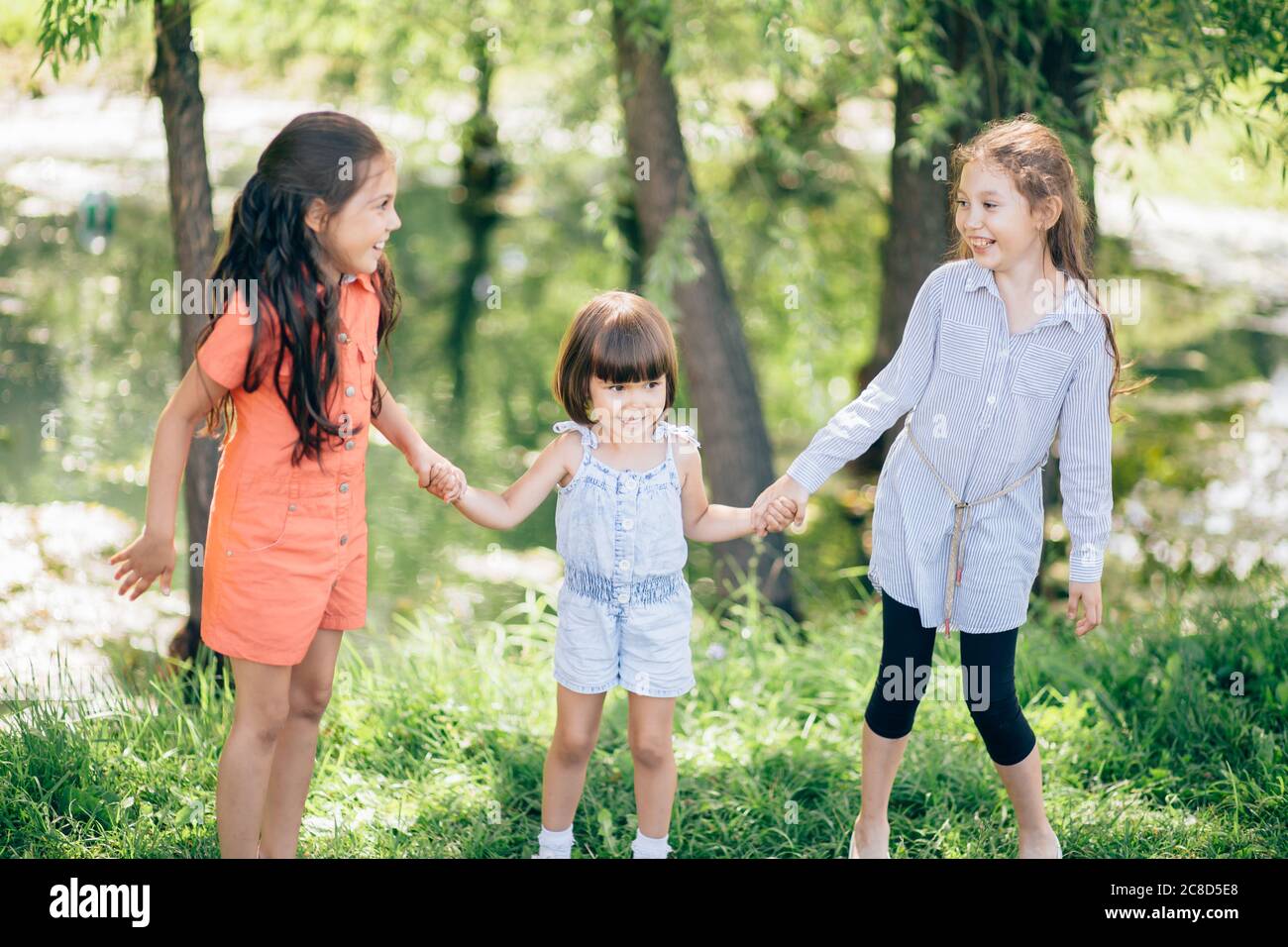 three kid sister friends girls group playing together in park Stock ...