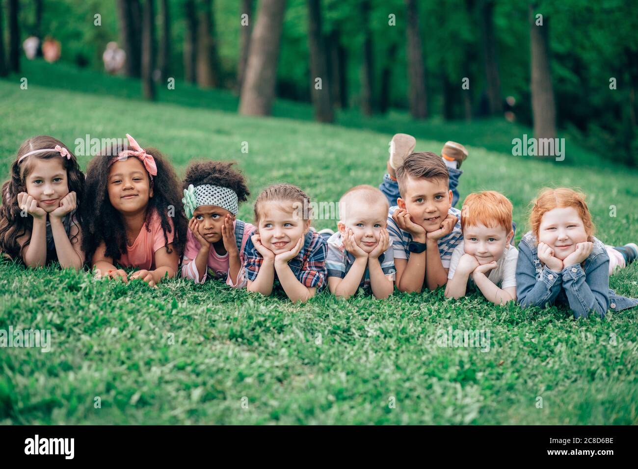 Smiling kids having fun at grass. Children playing outdoors in summer ...