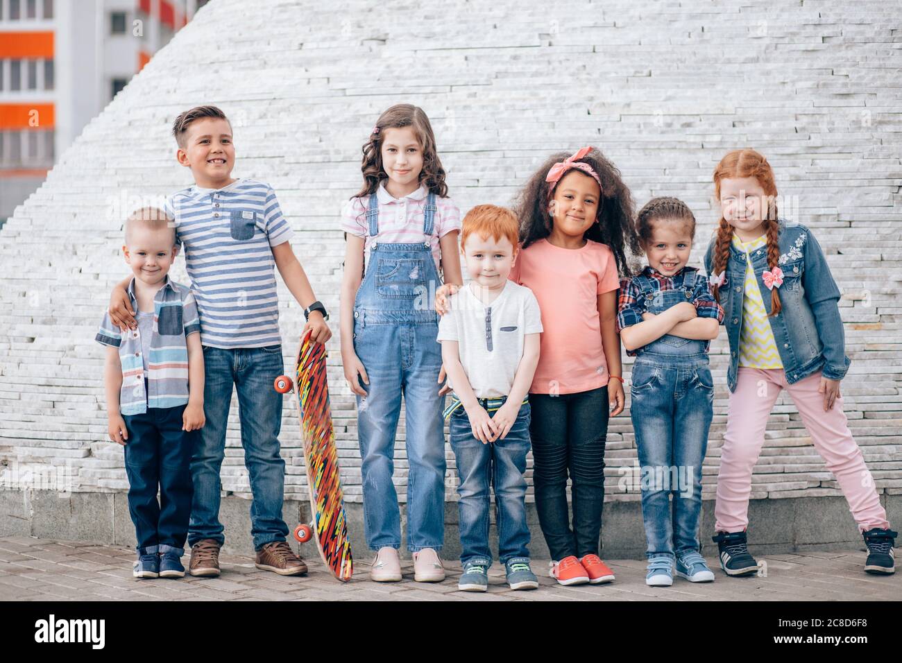 group of child stand near a wall. full length. posing outdoor. the ...