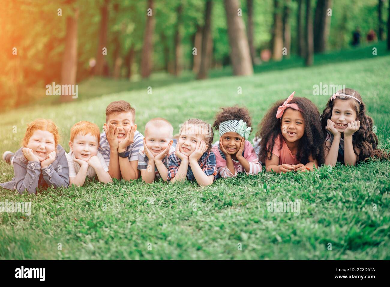 Cute children smiling in nature. Lying on the ground. Elementary age ...