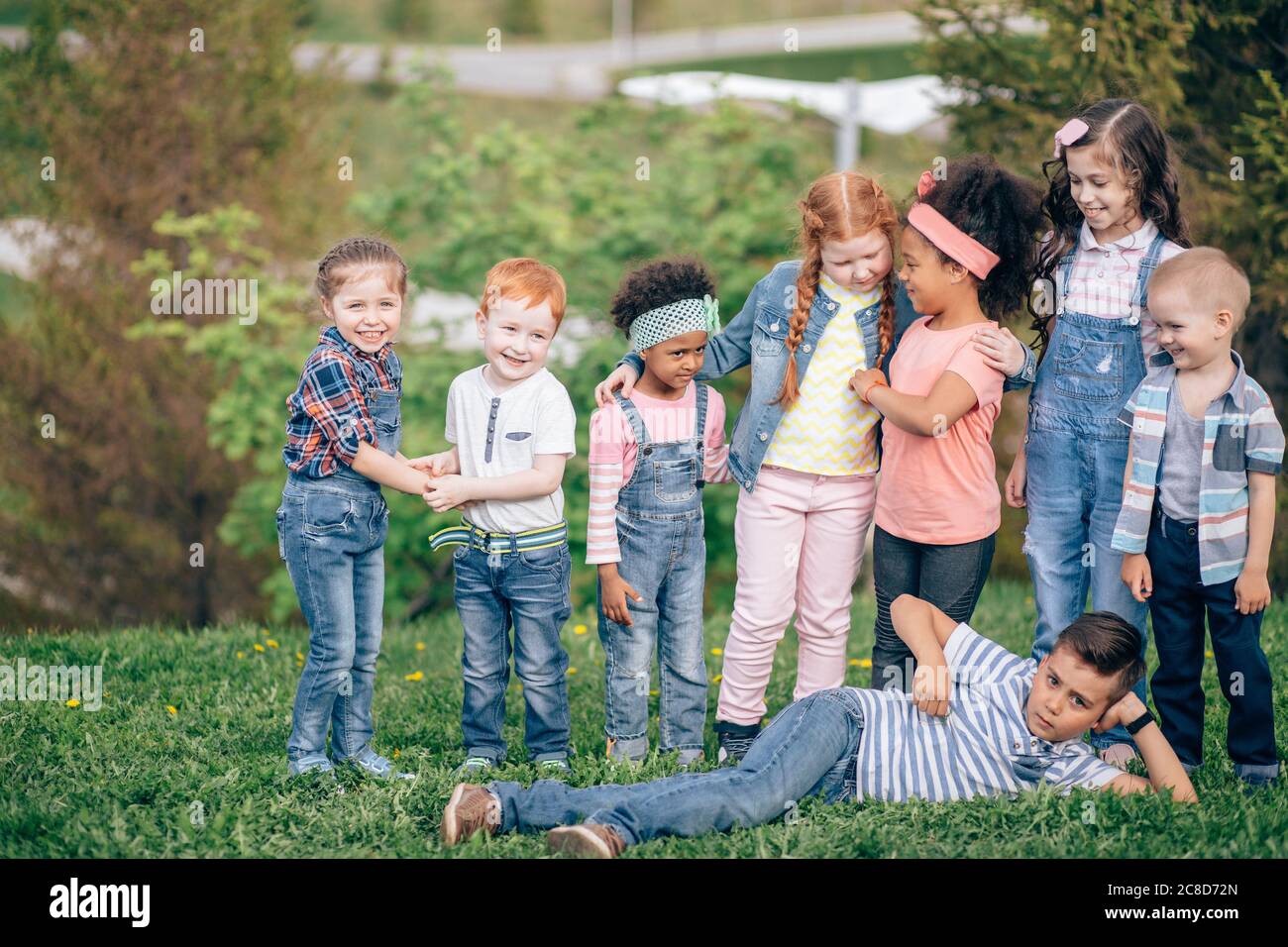 Kids, boys and girls playing, joking, hogging and having fun at sunset ...