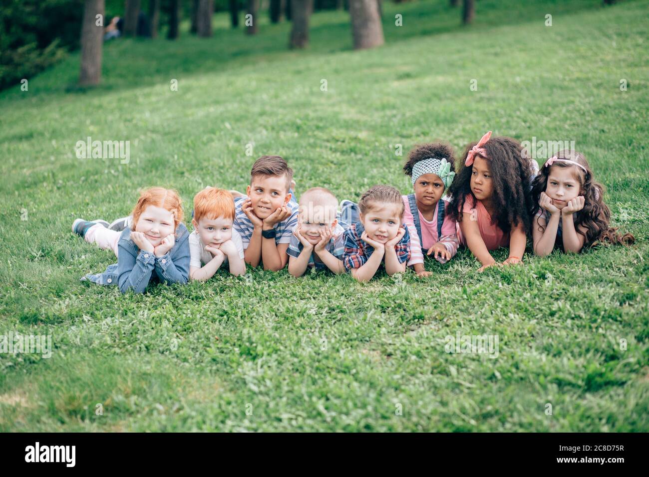 Smiling kids having fun at grass. Children playing outdoors in summer ...