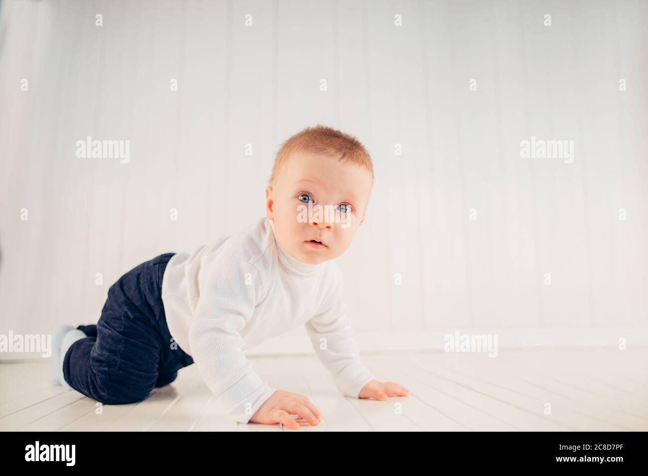 side view of pretty crawling baby on bed Stock Photo - Alamy
