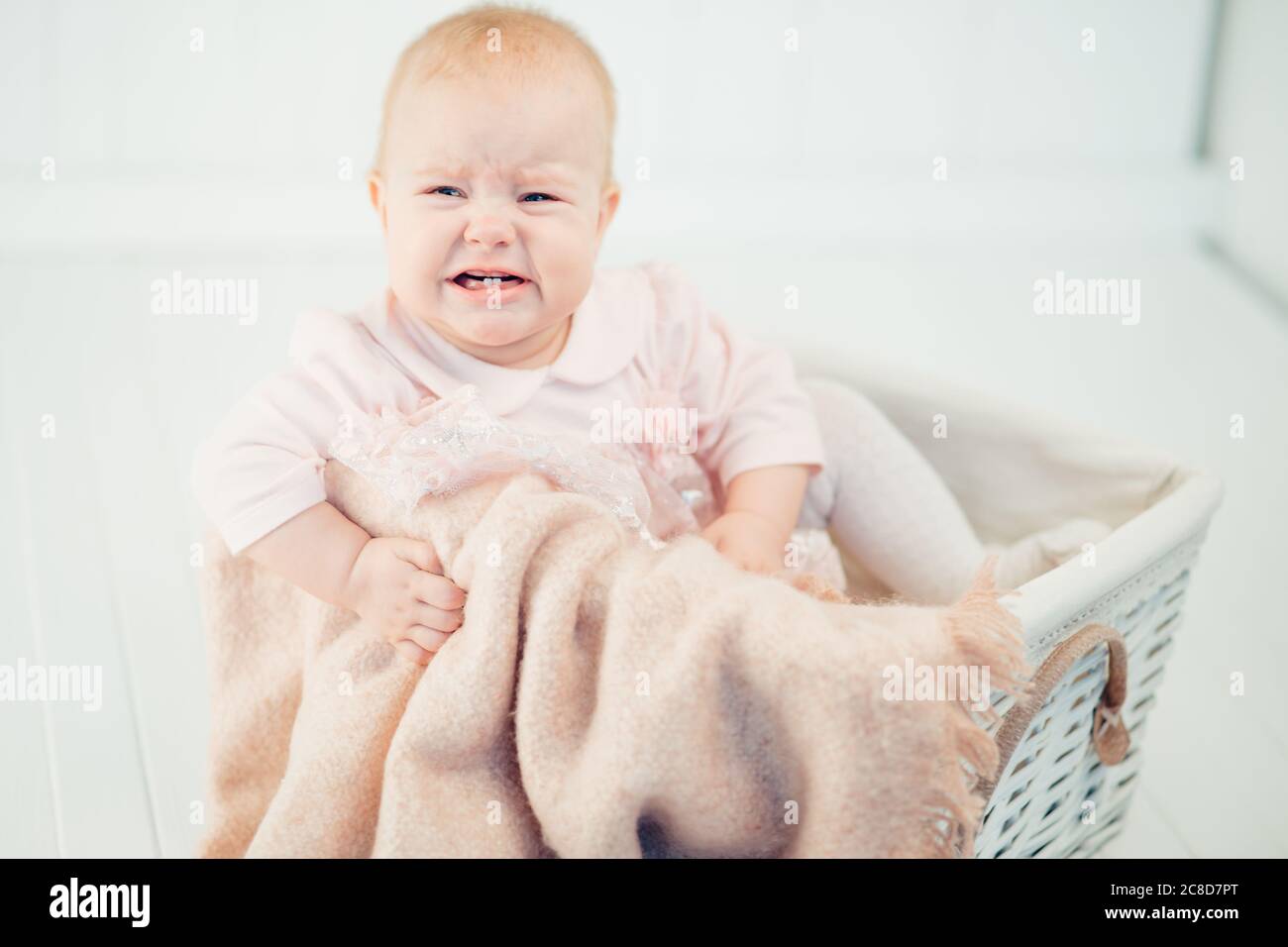 A young baby having a fit on the ground crying and making a pout face ...