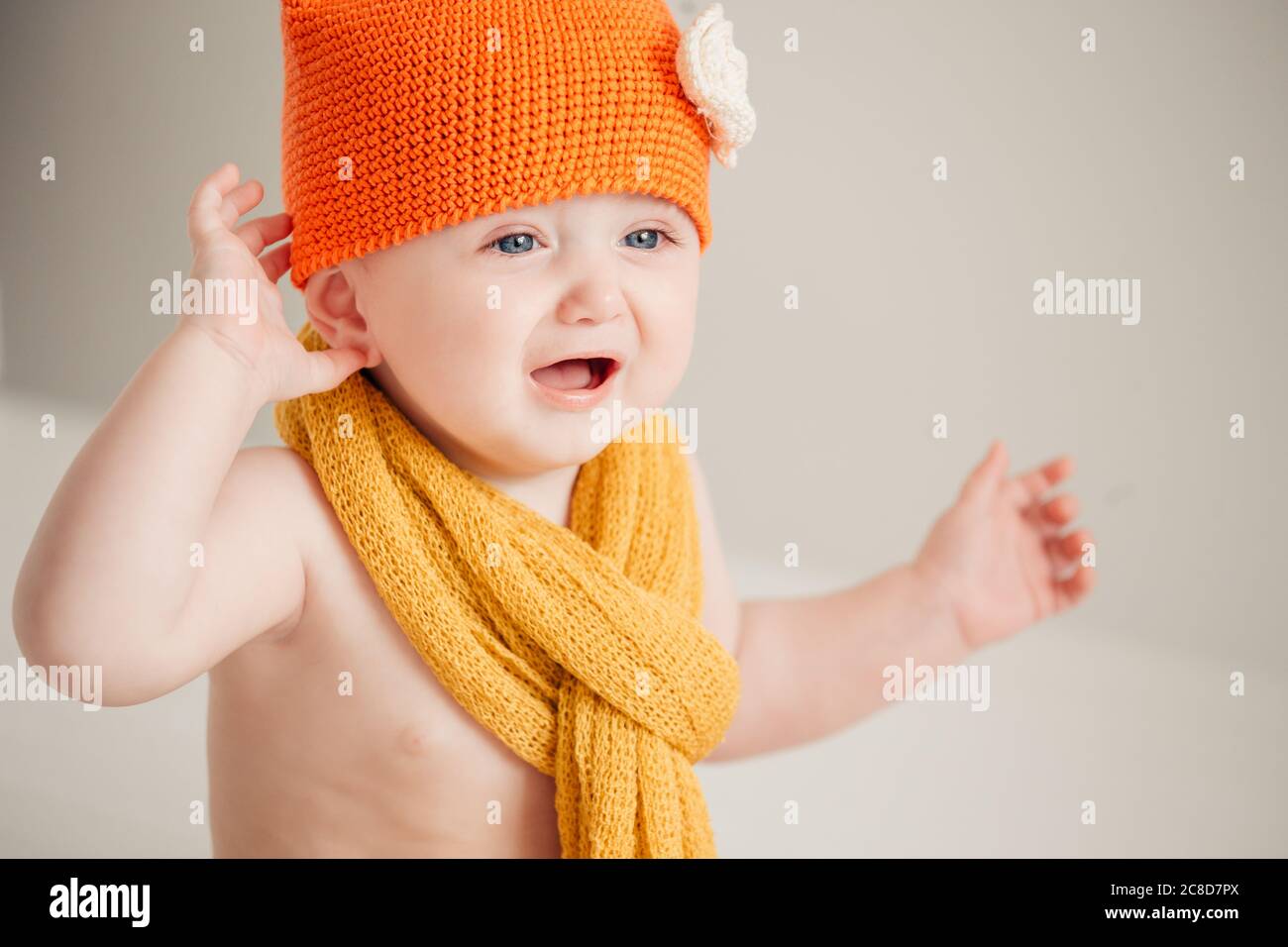 little baby crying on bed over white wall Stock Photo - Alamy