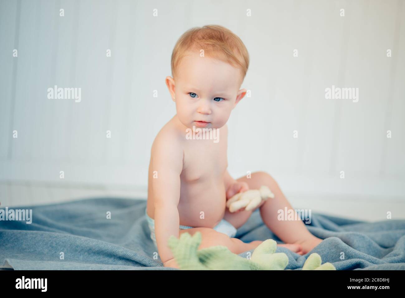 Beautiful cute soft baby sitting on bed Stock Photo - Alamy