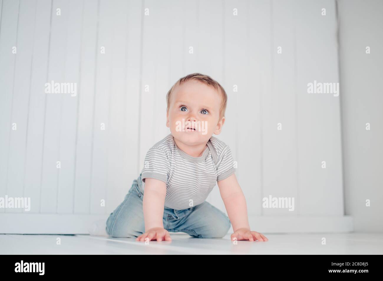 little baby crying on bed over white wall Stock Photo - Alamy
