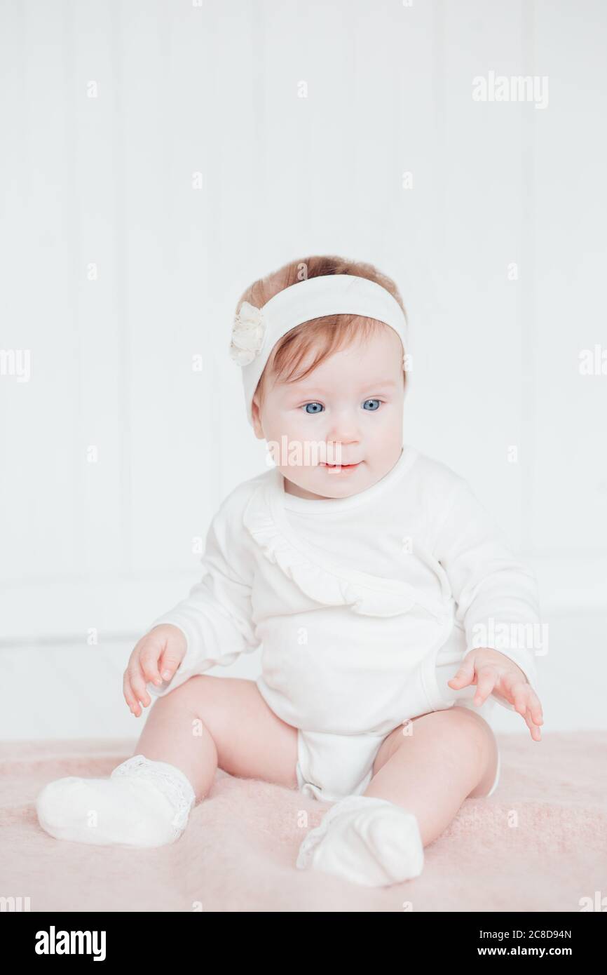 Beautiful cute soft baby sitting on bed Stock Photo - Alamy