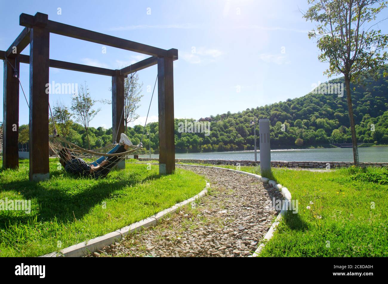 Side view of a pair of lovers in a large hammock with a view of the ...