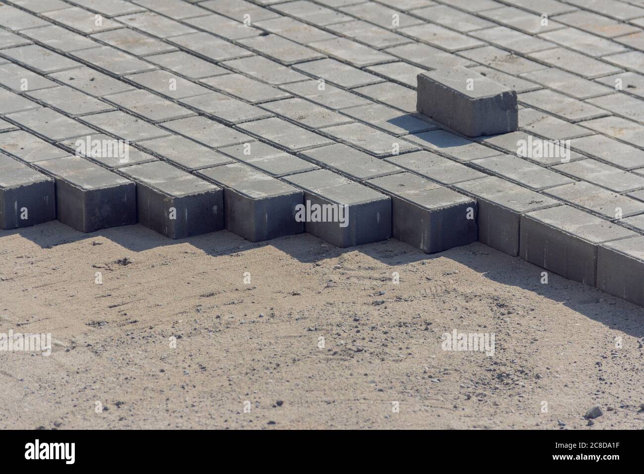 Construction of pavement near the house. Bricklayer places concrete ...