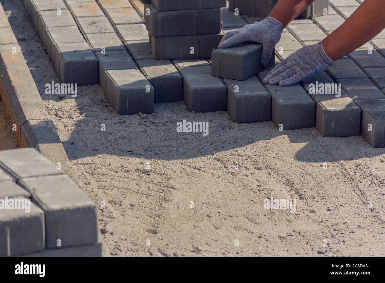 Construction of pavement near the house. Bricklayer places concrete ...