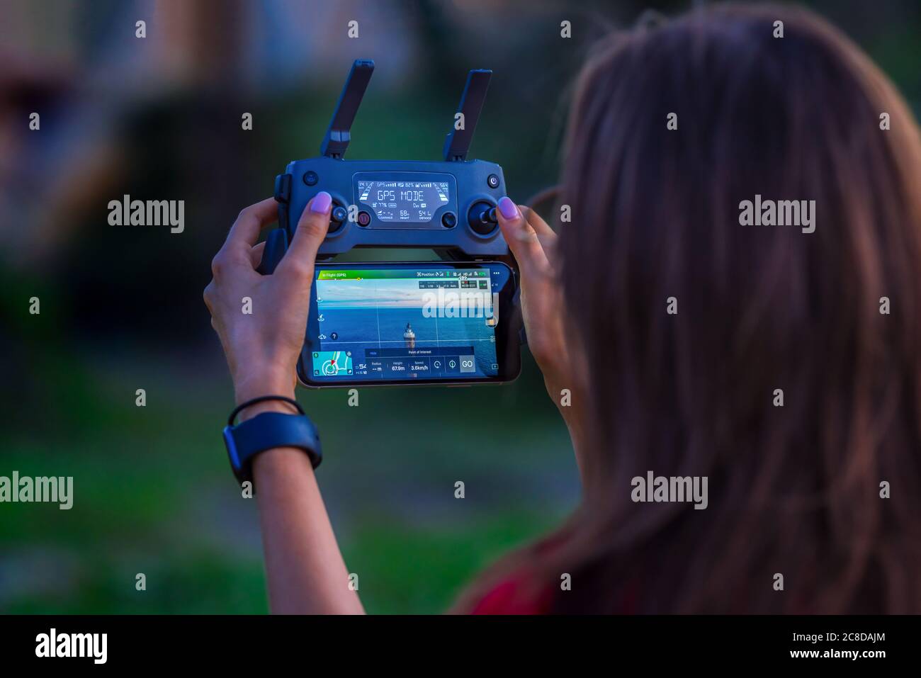 Young lady controls the drone with remote control and filming ...