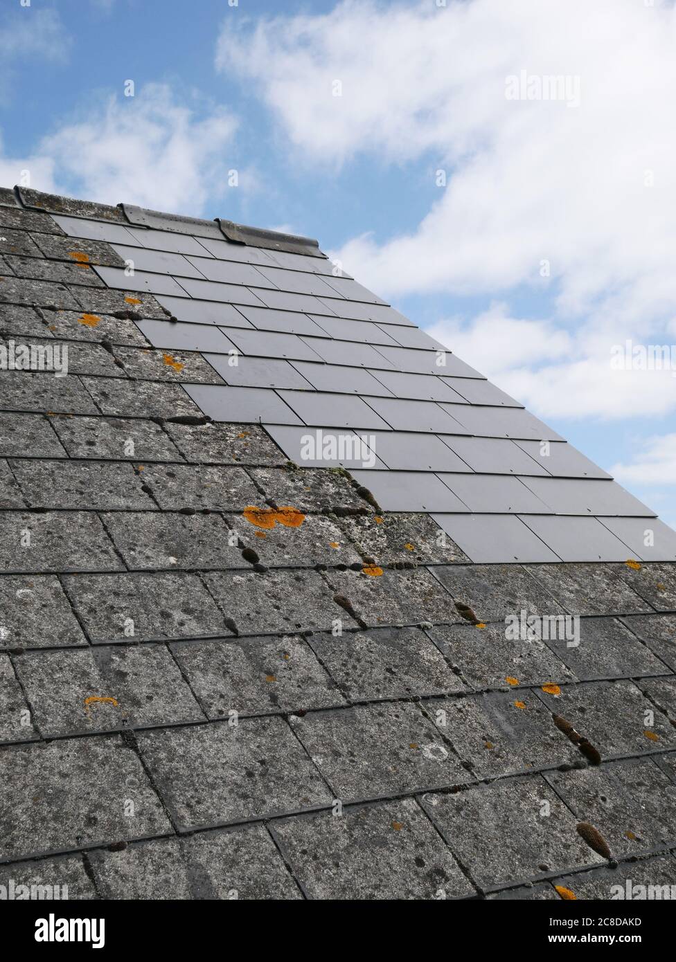 Gable end section of roof slate tiles repaired Stock Photo - Alamy