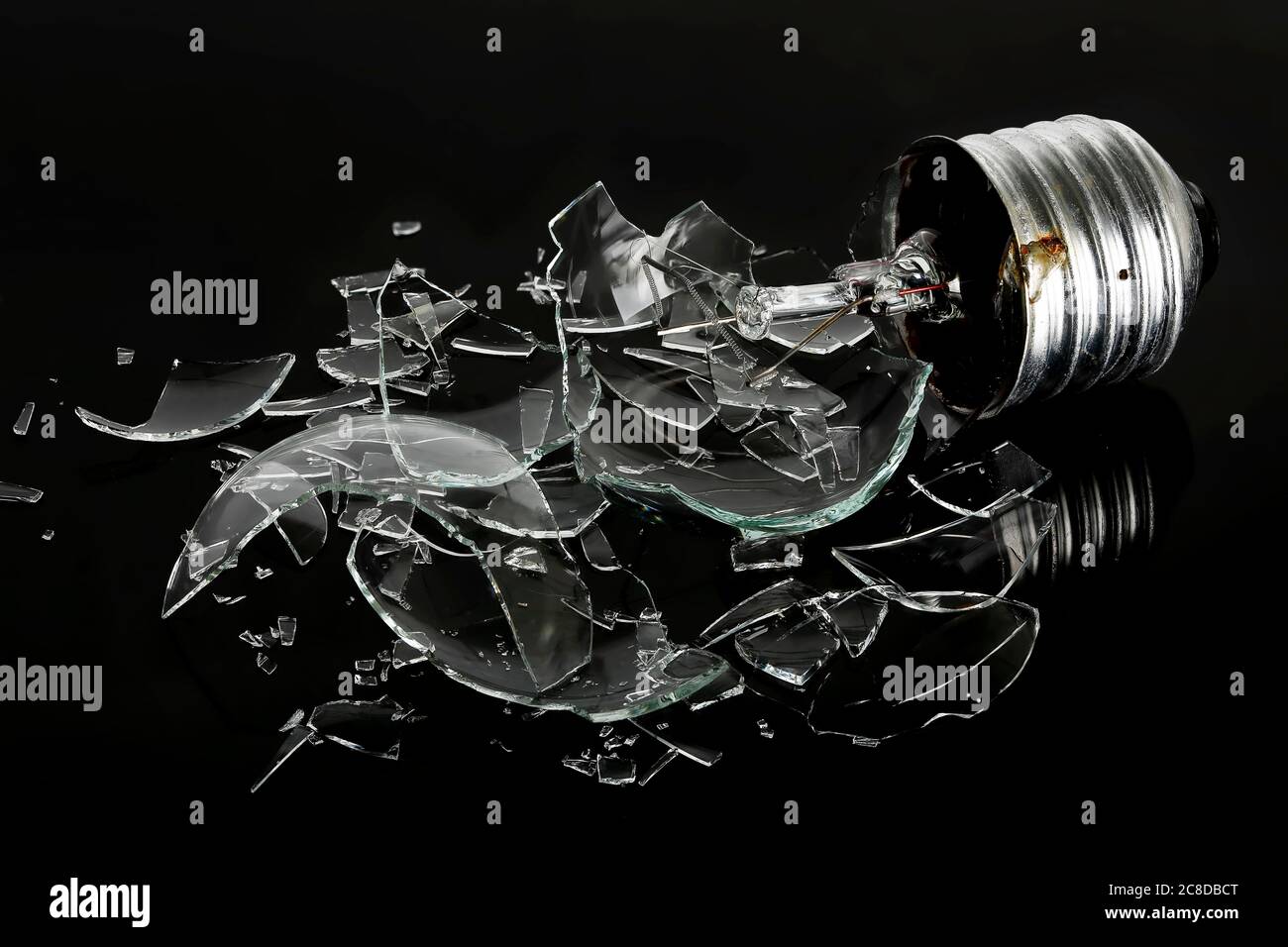 smashed light bulb on black background Stock Photo - Alamy