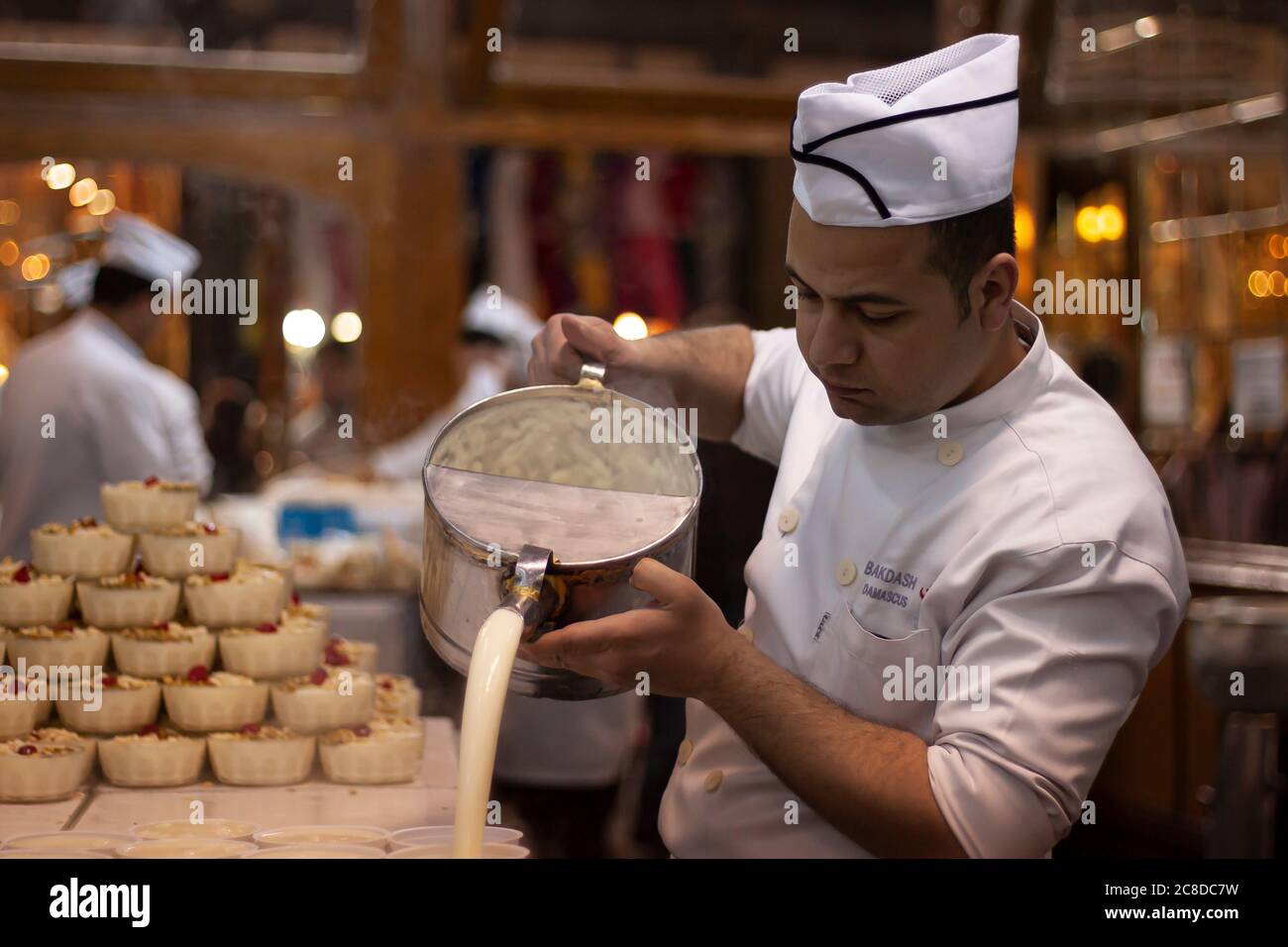 Damascus, Syria 03/28/2010: A chef wearing white dress and a hat is ...