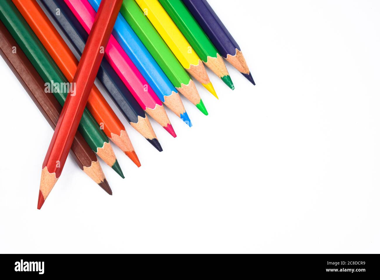 One red color wood pencil crayon placed on top of a row of different ...