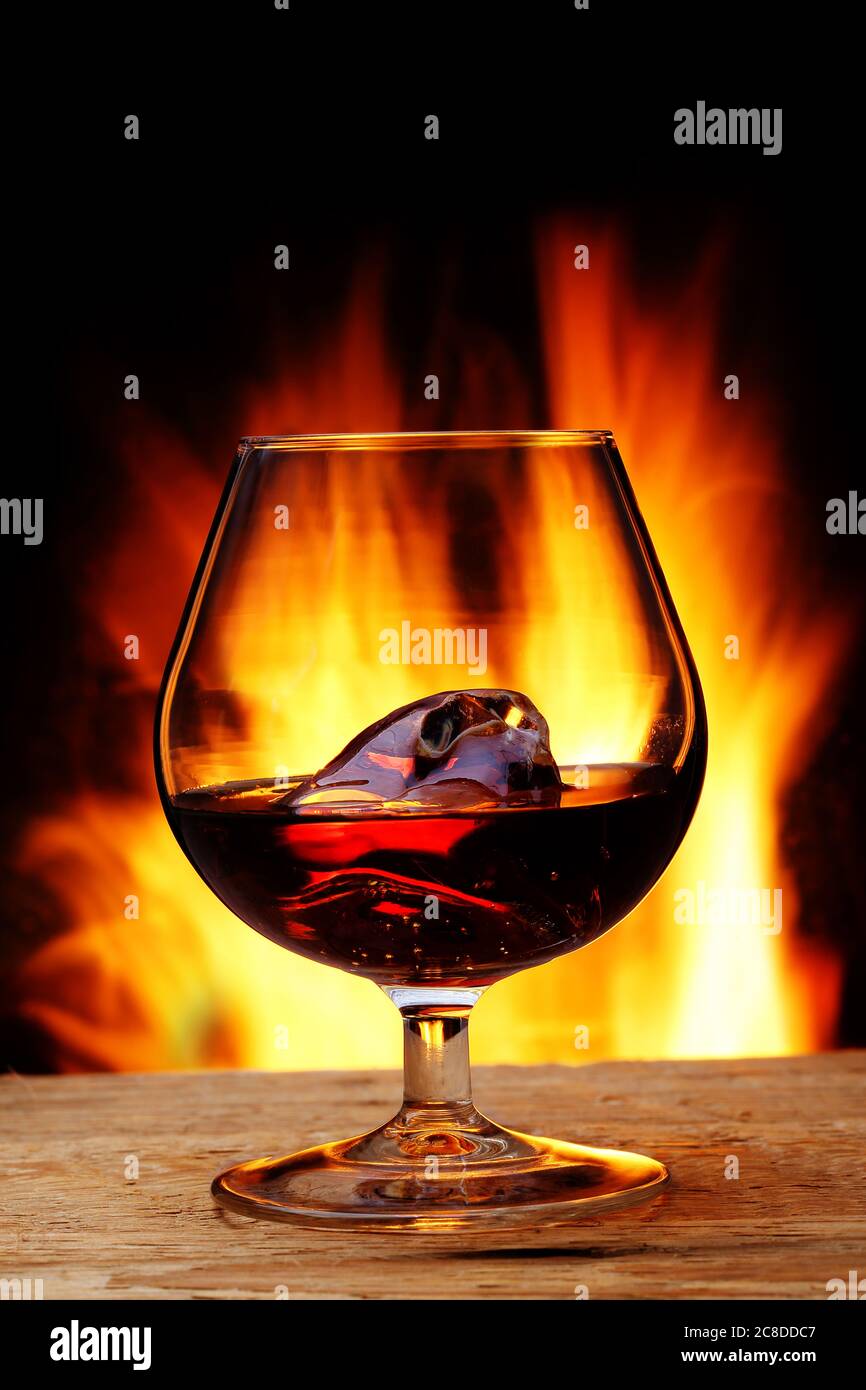 glass of cognac in front of the fireplace Stock Photo - Alamy