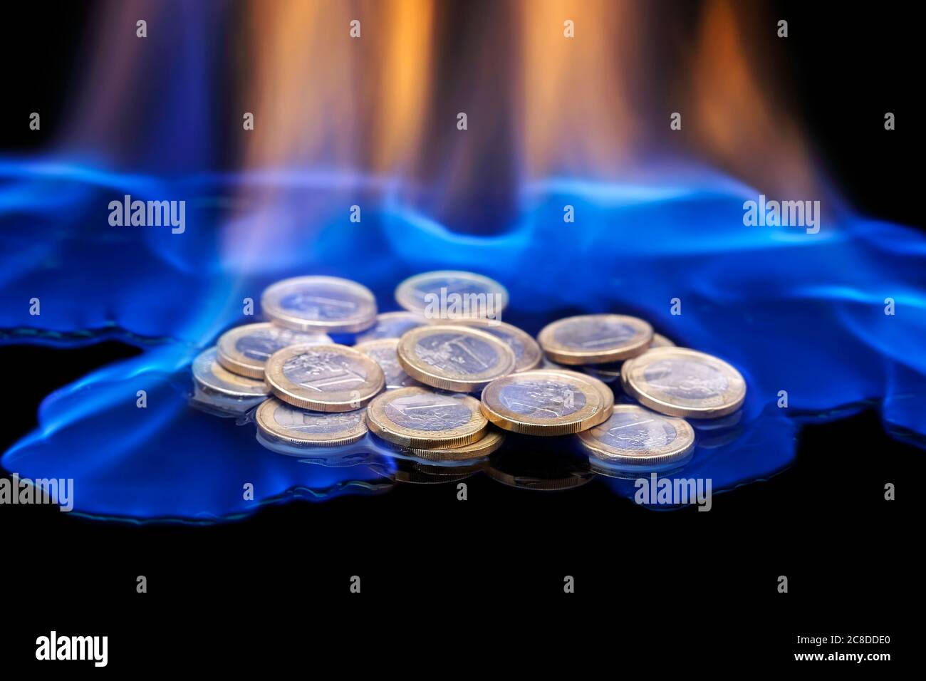 euro coins on fire on black background Stock Photo - Alamy