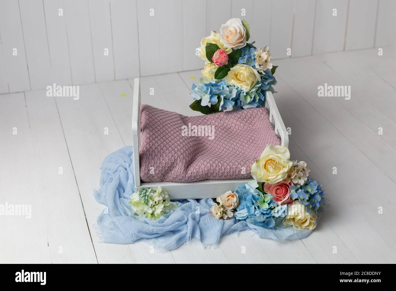 a small bed decorated with flowers. cot for a newborn photo shoot ...