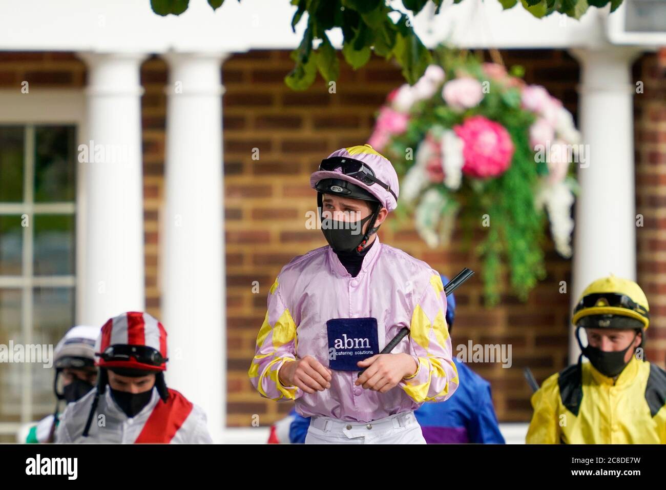 Jockey Charlie Bishop leads the jockeys to the parade ring at Sandown Park Racecourse Stock ...