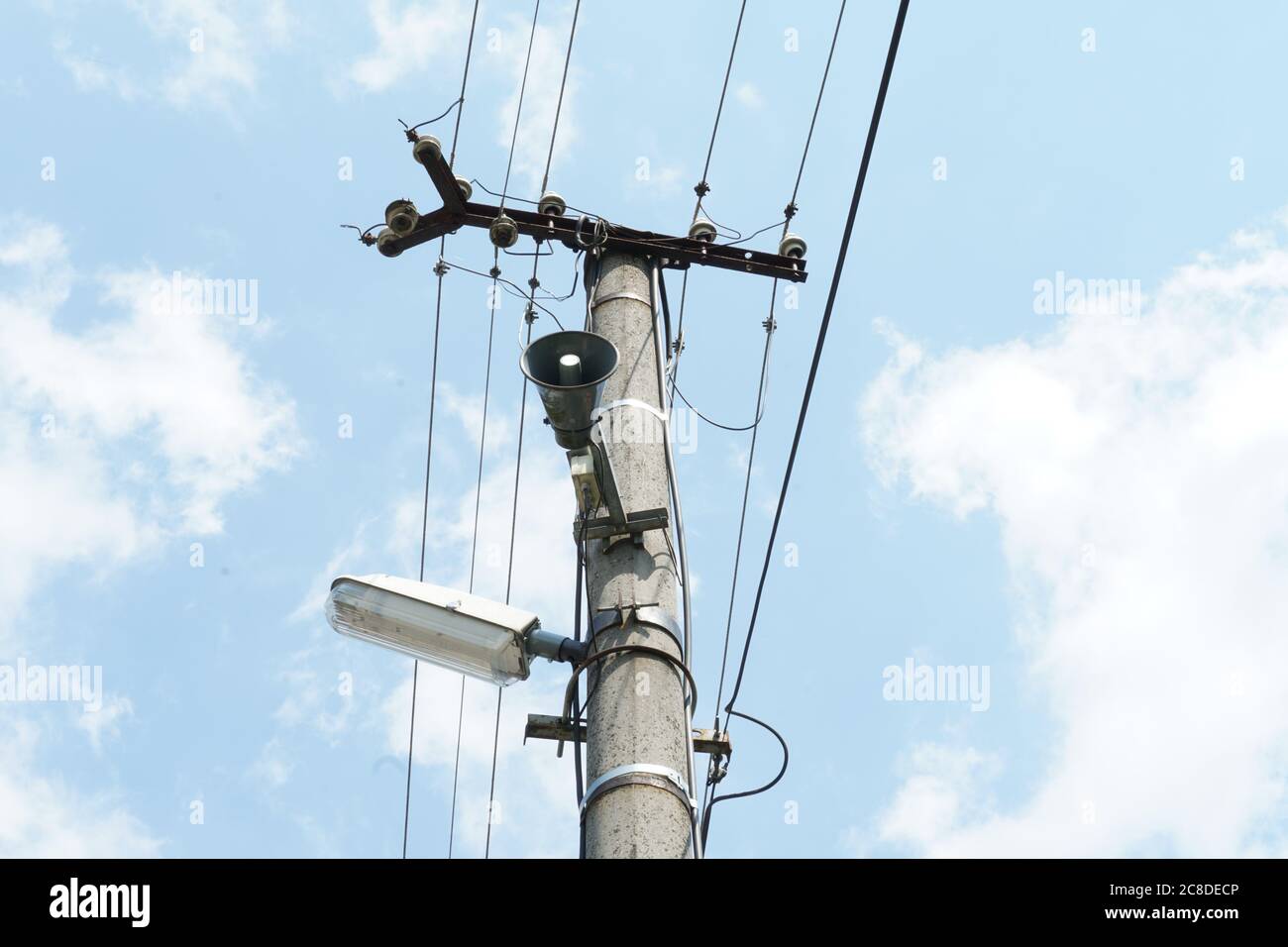 Electric mast or pillar of high voltage with megaphone, street lamp and ...