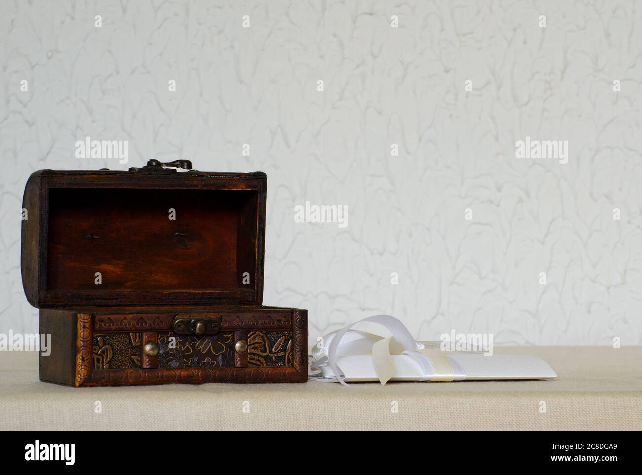 Open empty wooden box, white postcard with ribbons on a white ...