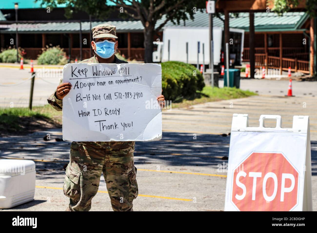 A Soldier holds a sign directing traffic at a Mobile Testing Team ...