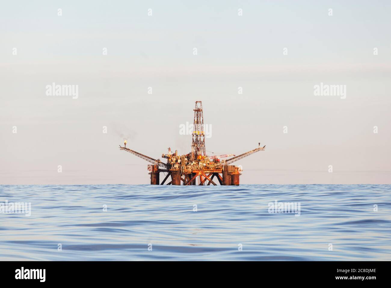 Oil rig at sunset time Stock Photo - Alamy