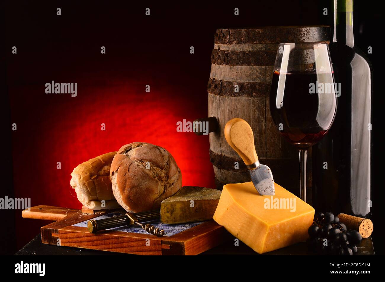 Glass of red wine and the bottle nearby, bread and barrel studio shot ...