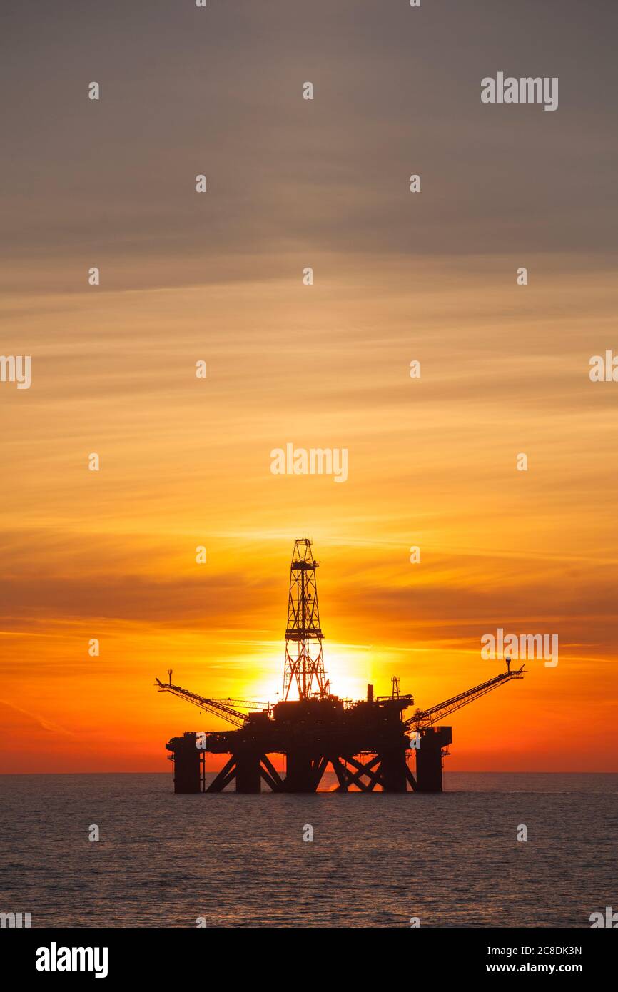 Oil rig at sunset time Stock Photo - Alamy