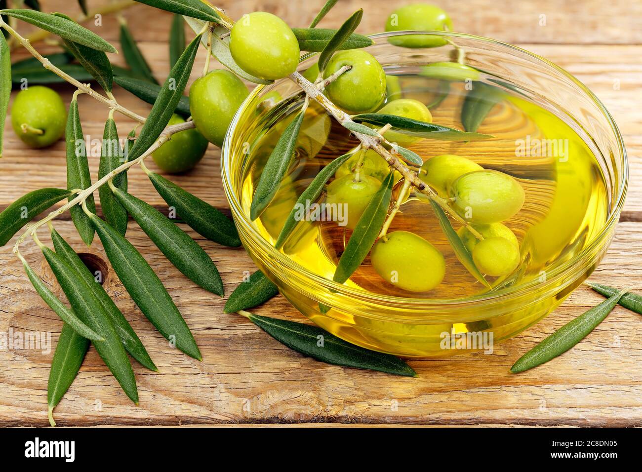 olive tree branch dipped in bowl of olive oil Stock Photo - Alamy