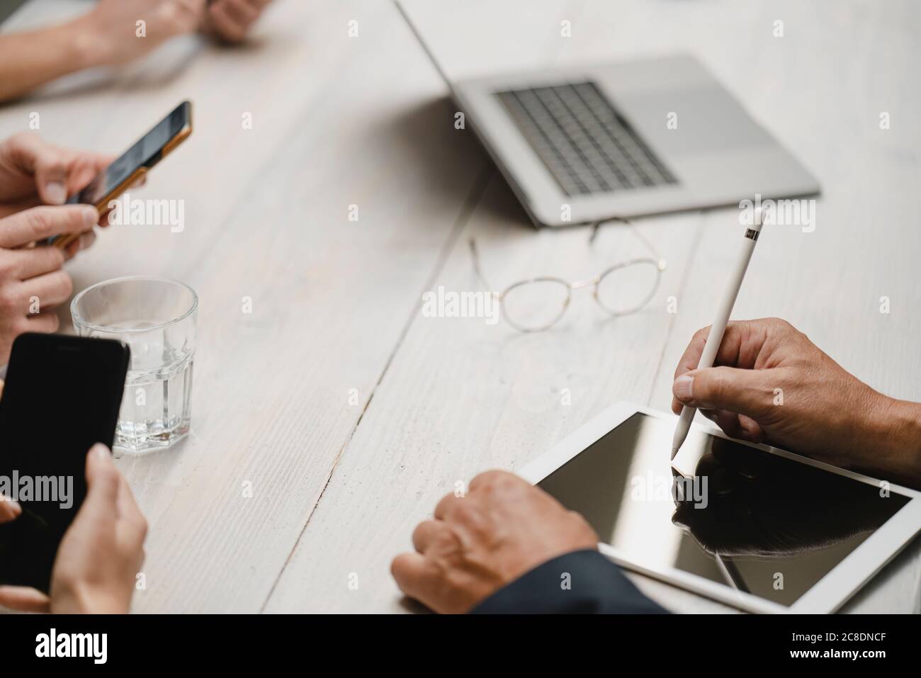 Business people working in office using portable devices, close up ...
