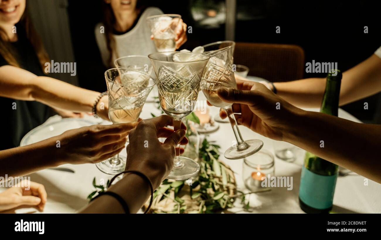 Friends making celebratory toast during dinner Stock Photo - Alamy