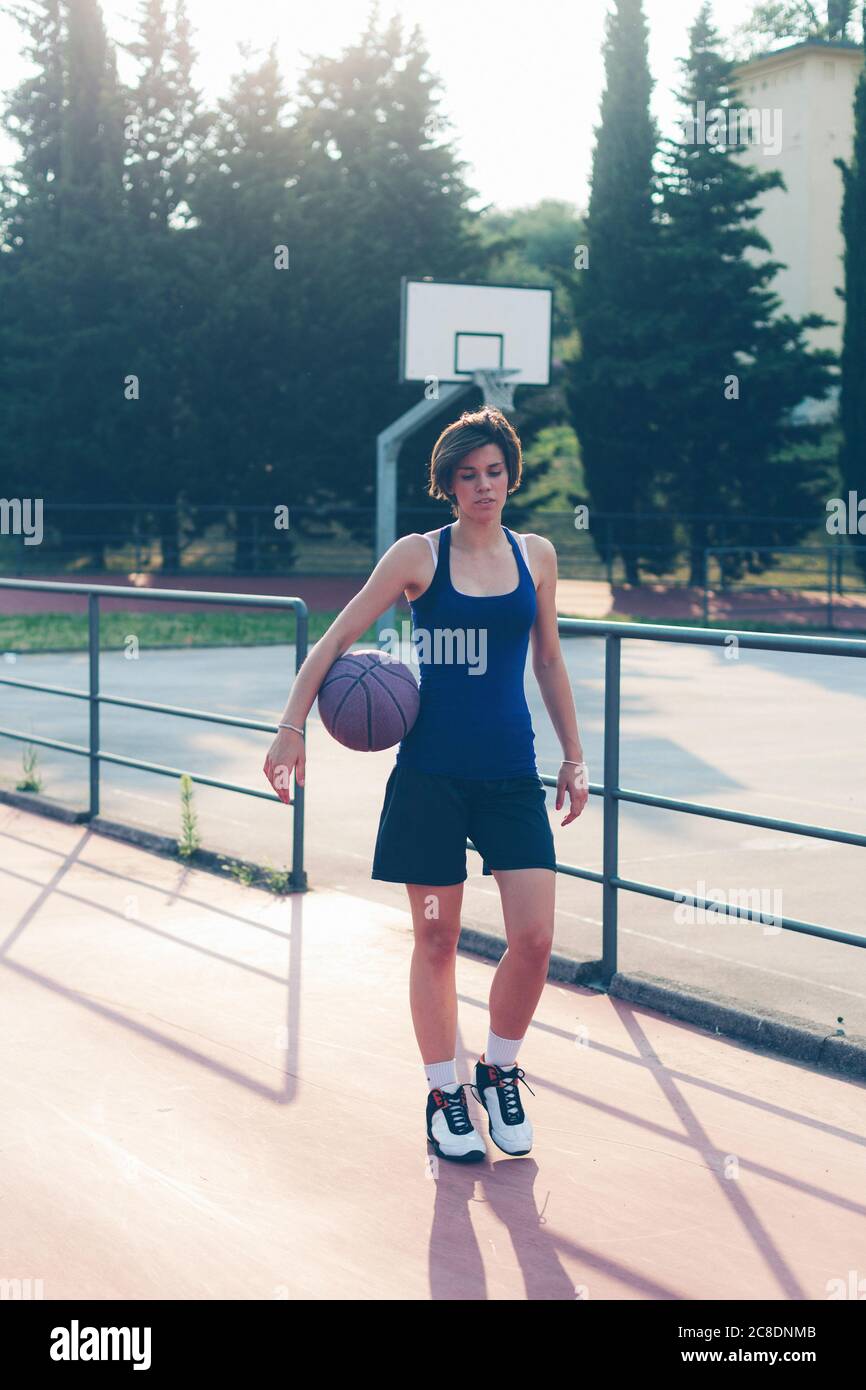 Female athlete walking with basketball on court Stock Photo - Alamy