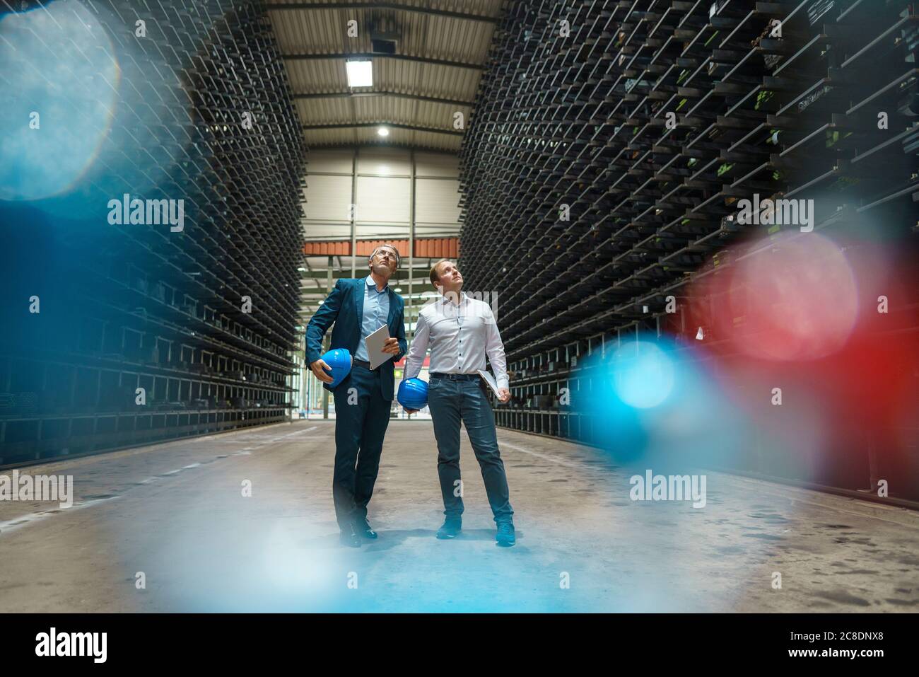 Two businessmen in a high rack warehouse of a factory Stock Photo - Alamy