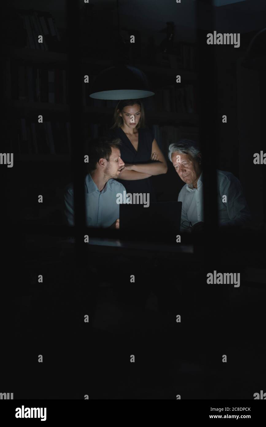 Team of business people working late in office, disussing solutions ...