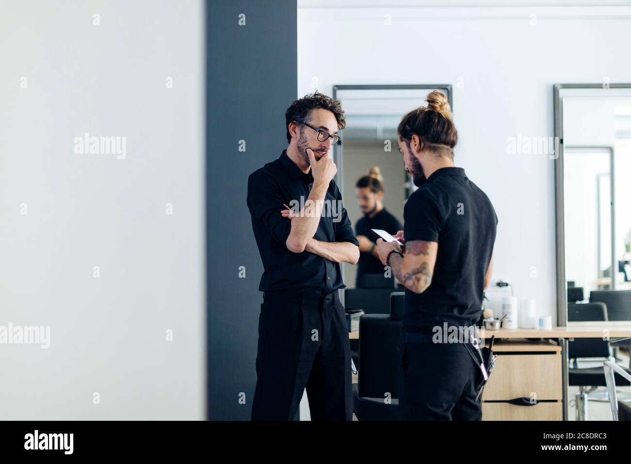 Male barbers talking in hair salon Stock Photo - Alamy