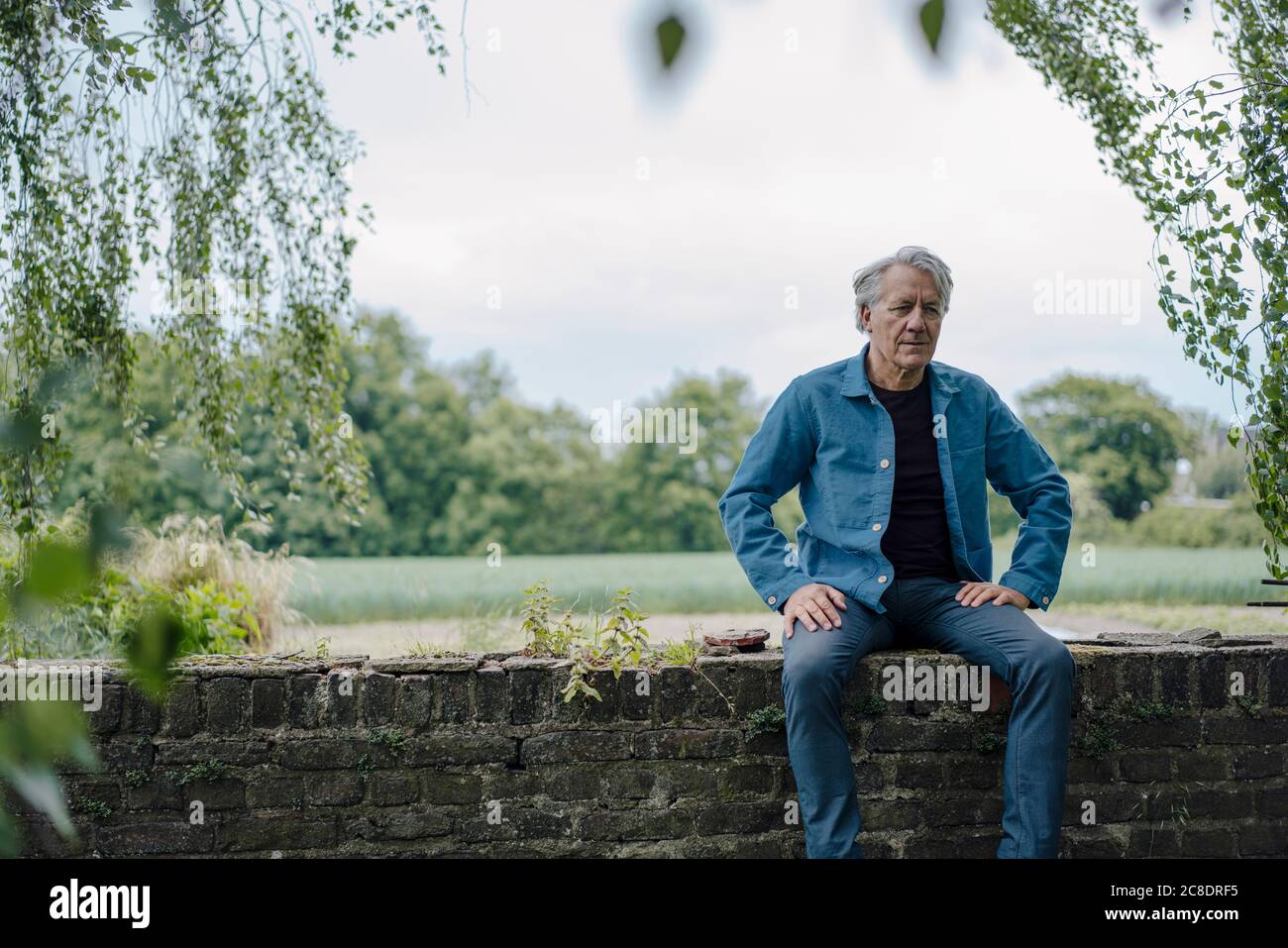 Man sitting on brick wall hi-res stock photography and images - Alamy