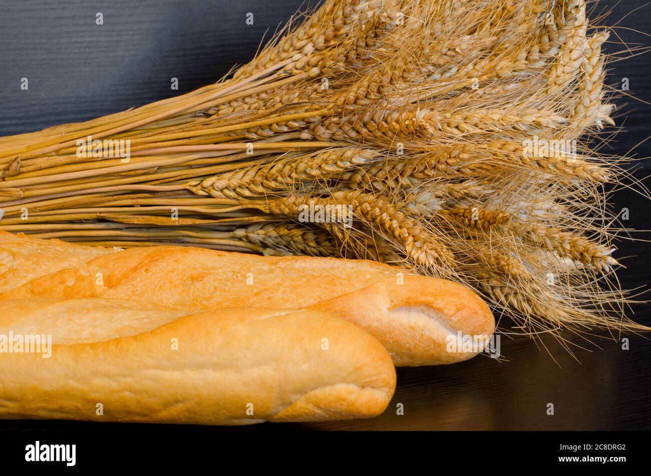White loaves and a sheaf on a dark background, close-up Stock Photo - Alamy