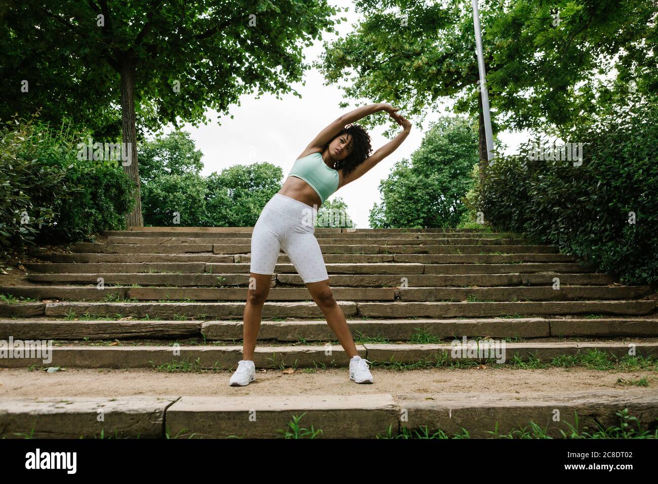 Athletic young woman stretching arms on steps Stock Photo - Alamy