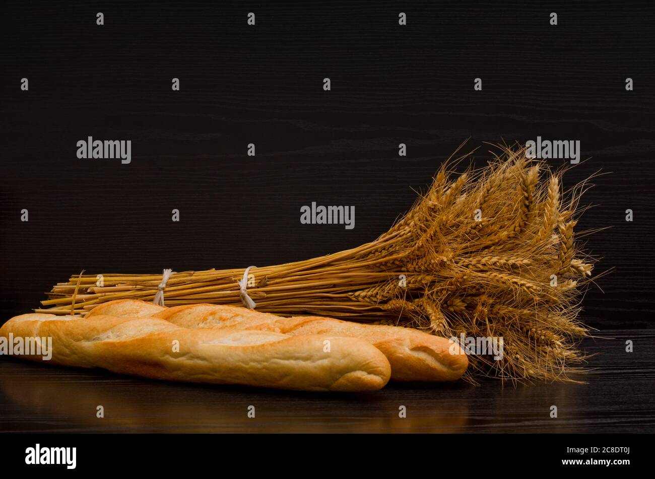 Two white loaf and a sheaf on a black background, with space for text ...