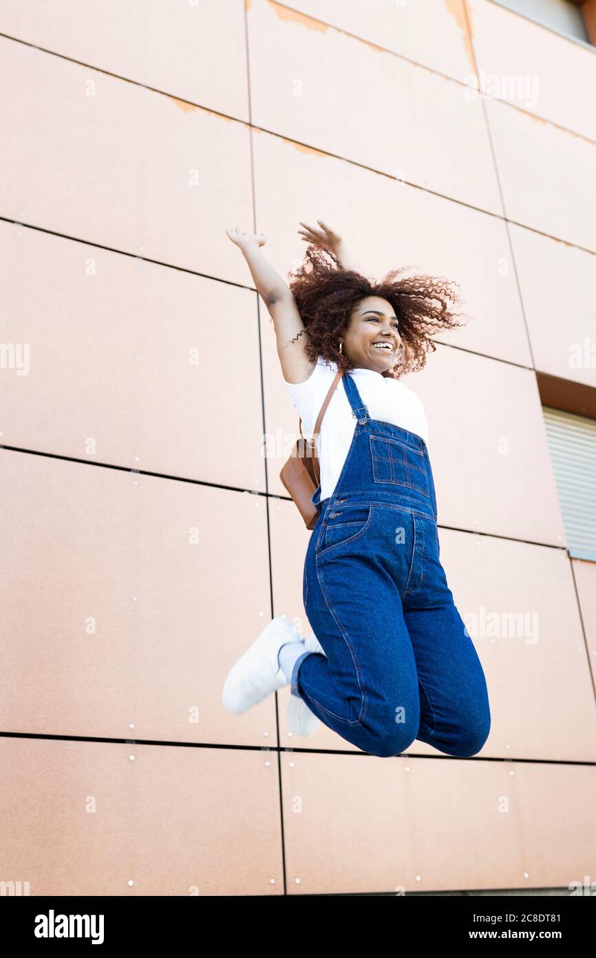 Beautiful woman jumping raising arms hi-res stock photography and ...