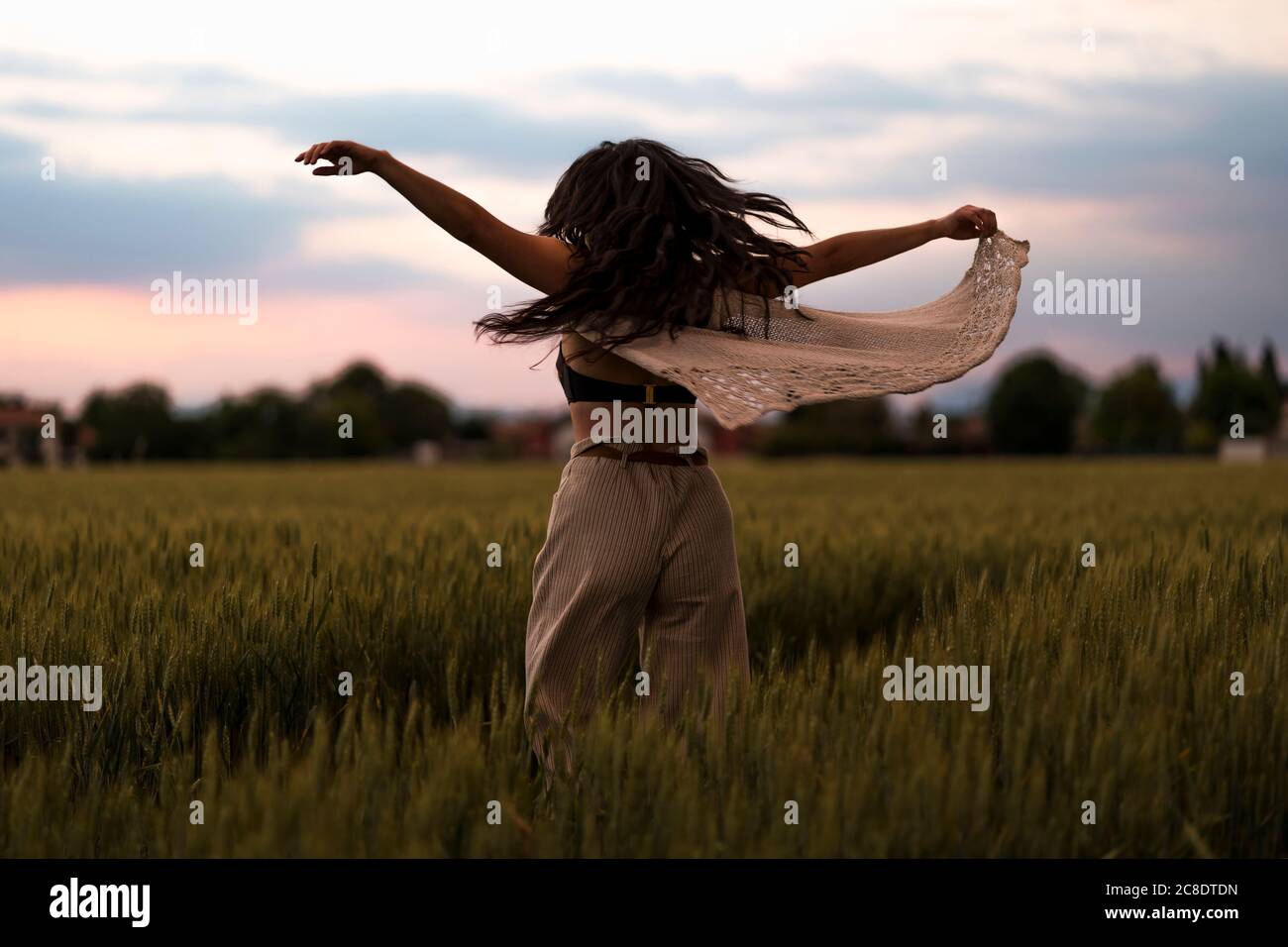 Woman dancing at field in the evening light Stock Photo - Alamy