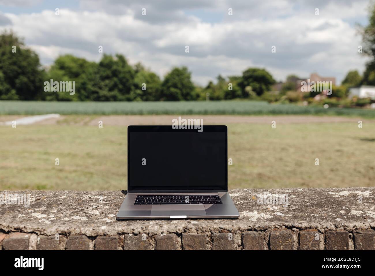 Laptop on brick wall in the countryside Stock Photo - Alamy