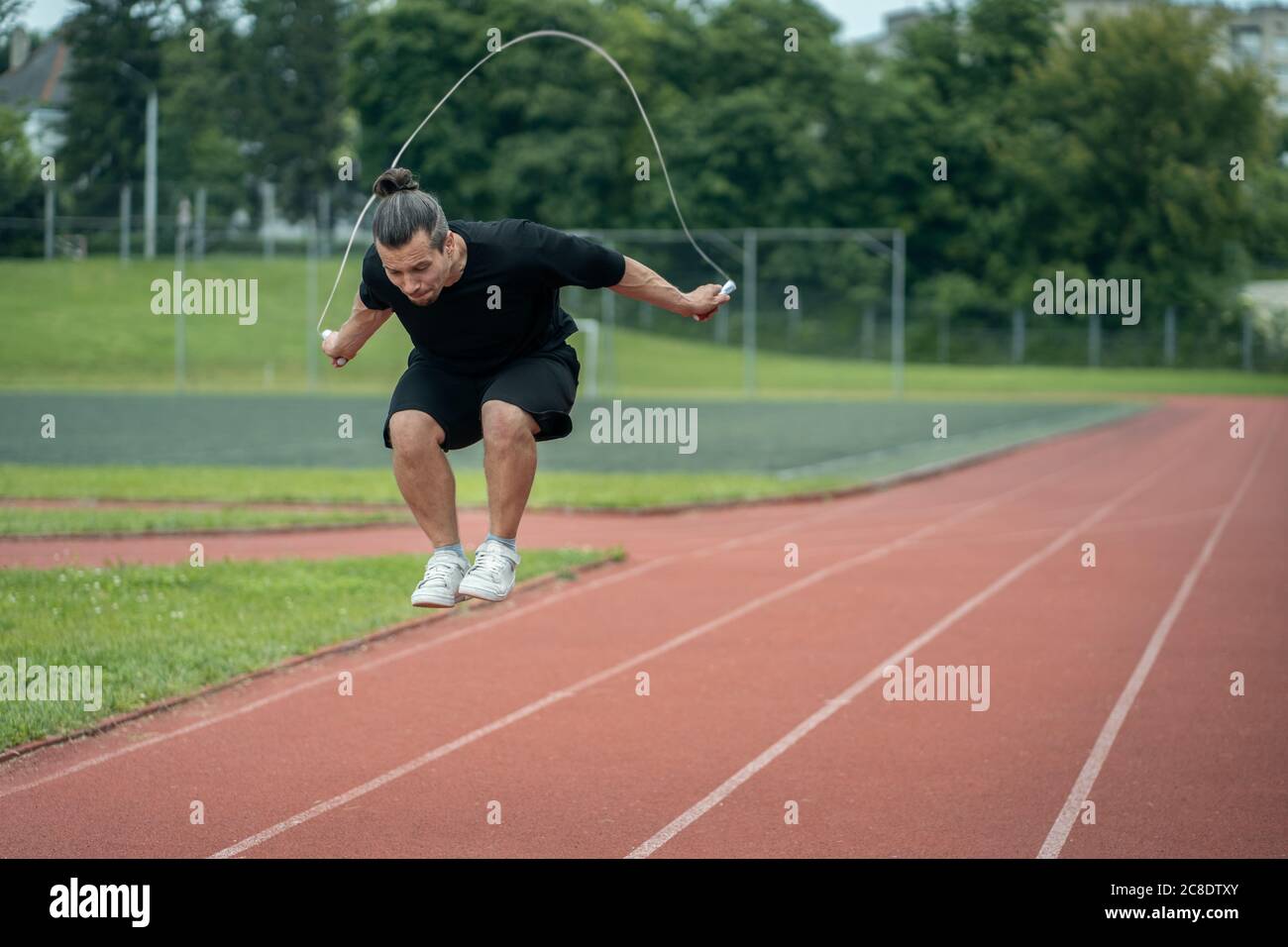 young athlete has workout and jumps on skipping rope outdoor Stock ...