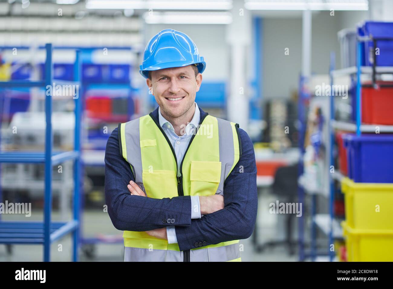 Confident male supervisor in hardhat and reflective clothing standing ...