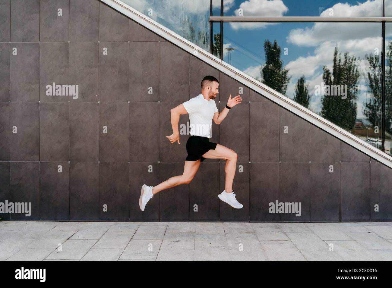Man running along a building Stock Photo - Alamy